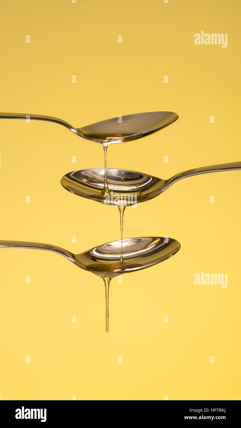 Pouring over three spoons Stock Photo - Alamy