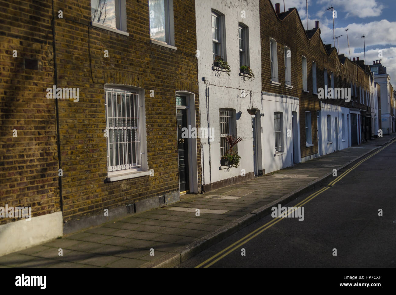 street with typical English buildings, brick buildings, yellow lines on ...