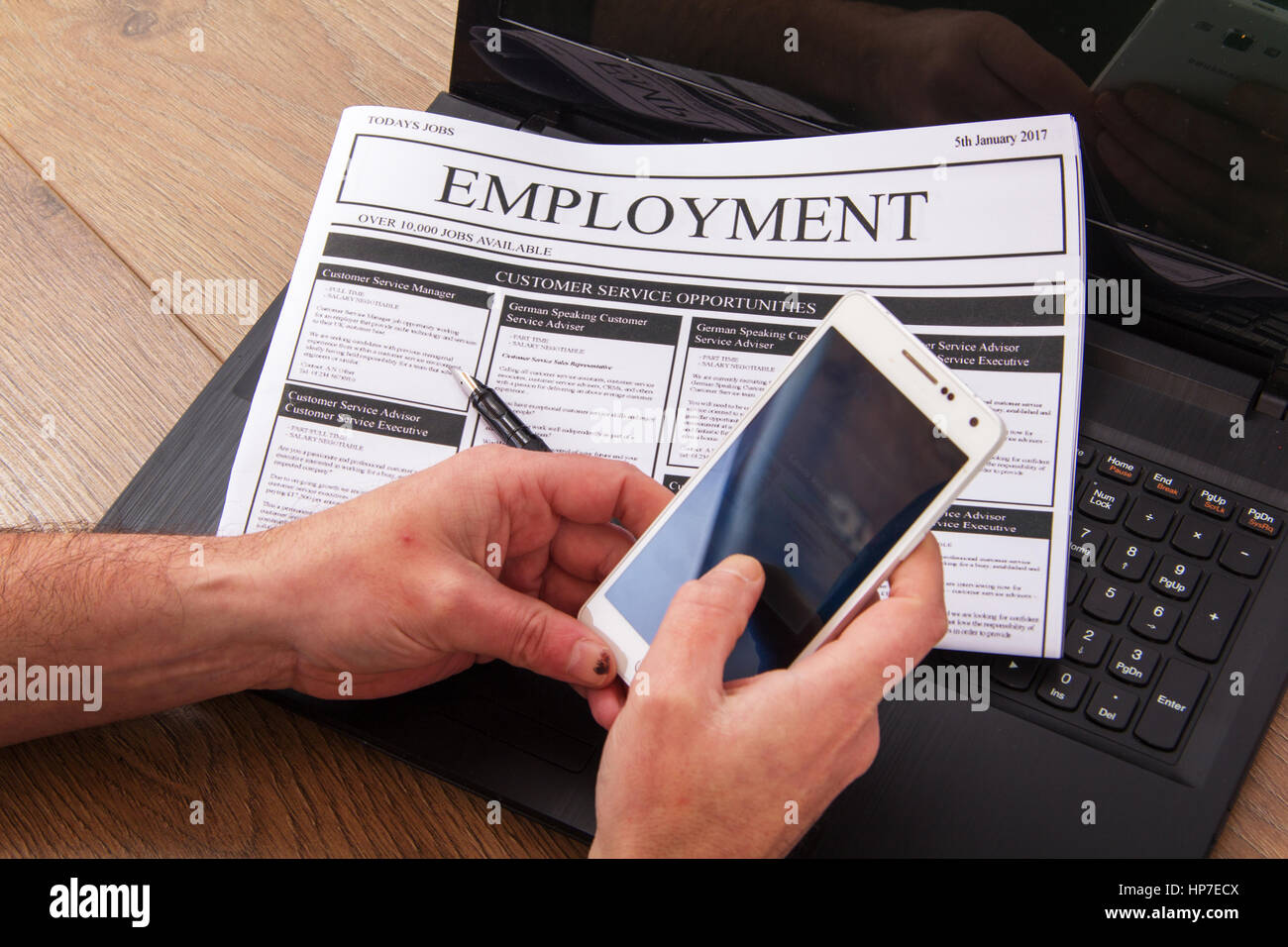 Searching for a new job or employment in a newspaper Stock Photo - Alamy