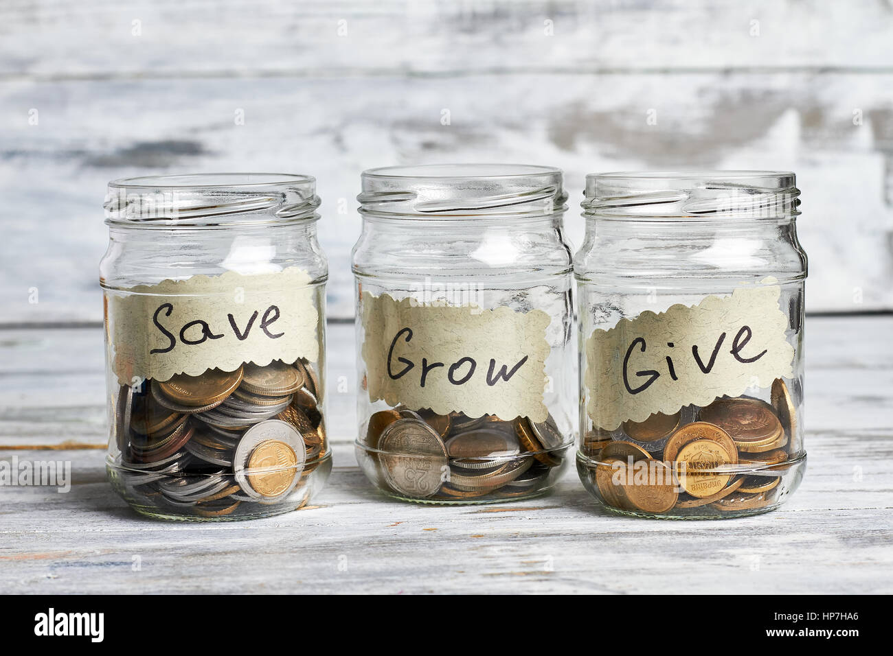 Three glass containers with coins. Idea of spending money Stock Photo ...
