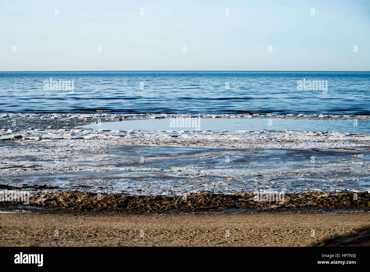 people enjoying frozen beach in winters cold. walking and relaxing ...