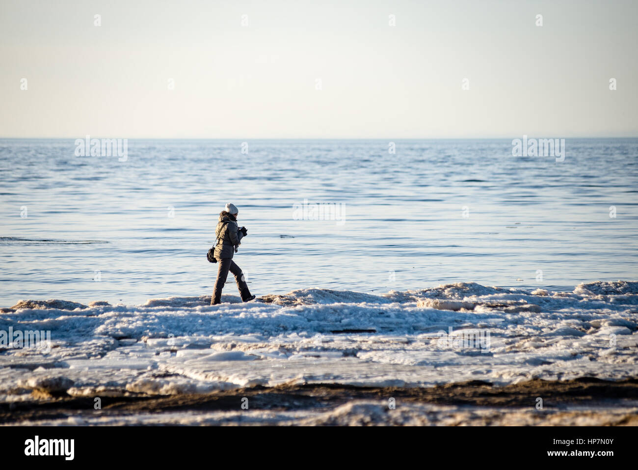 people enjoying frozen beach in winters cold. walking and relaxing ...