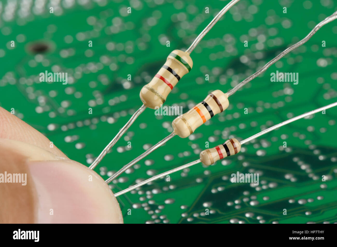 technician holding three different value of resistors Stock Photo - Alamy
