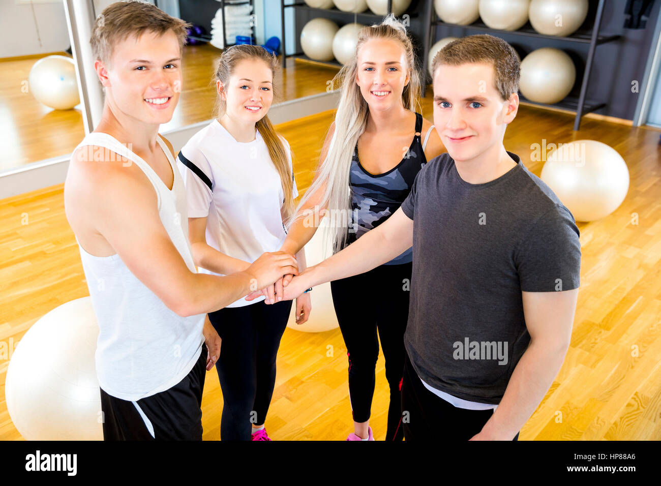 Happy and smiling fitness workout group holding hands at the gym center ...