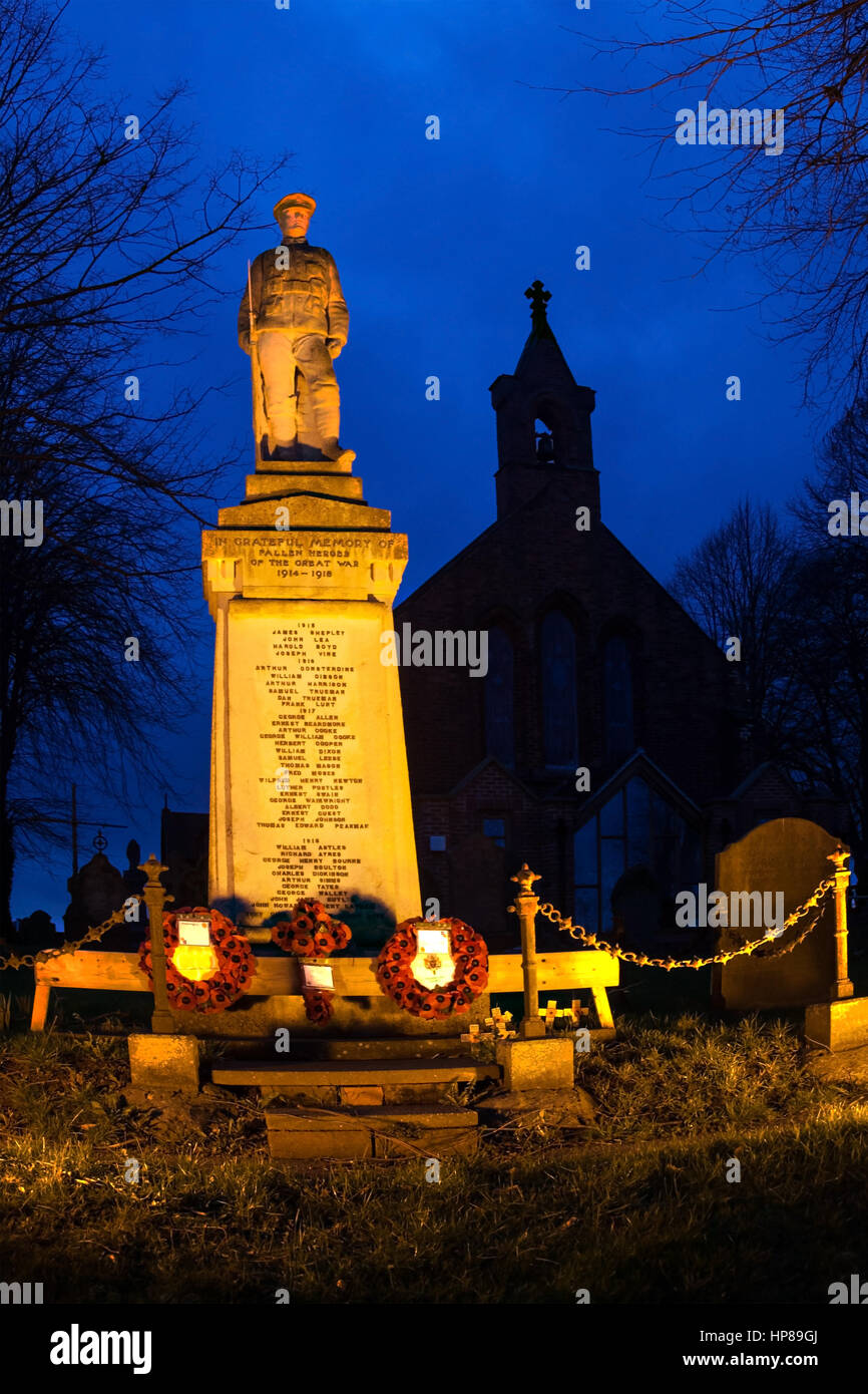 Floodlit war memorial in front of a silhouette of Christ church ...