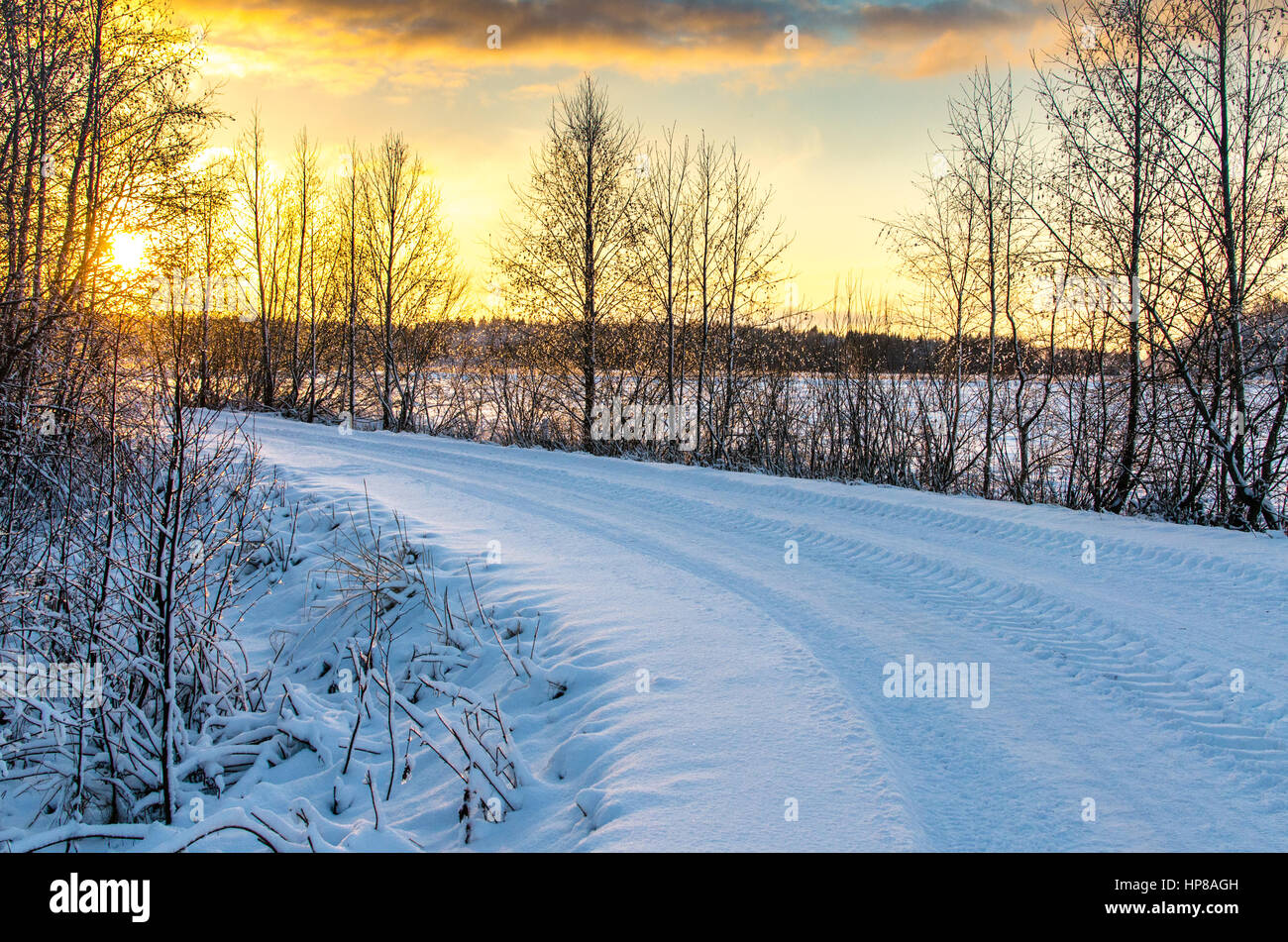 Sunset sky under a snowy countryside road Stock Photo - Alamy