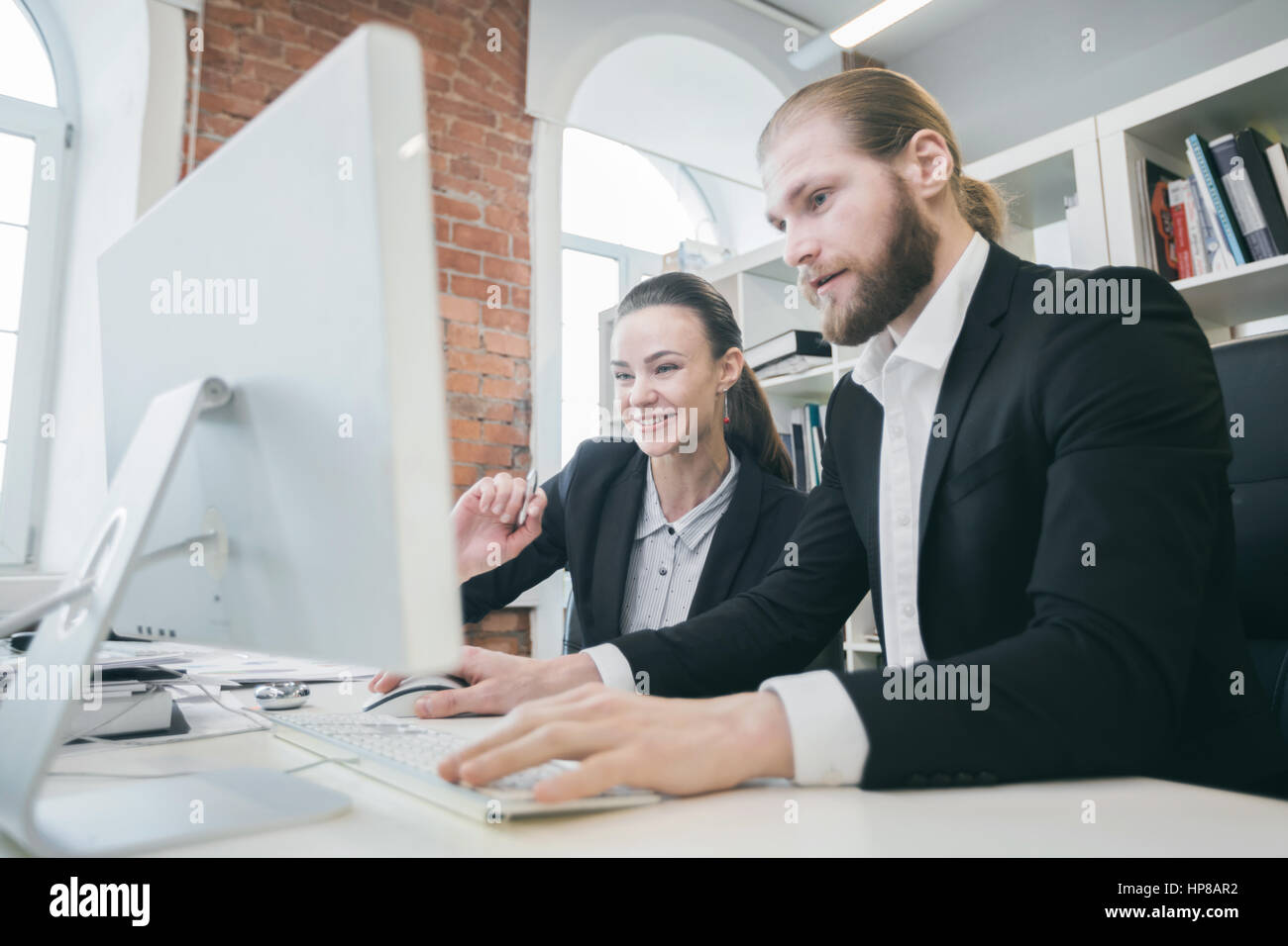 Two business people working together in the office looking at one ...