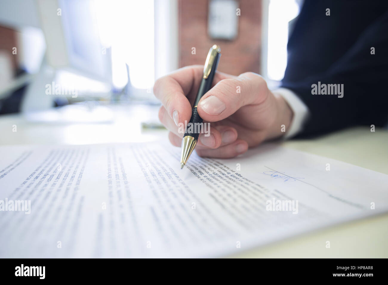 Businessman sitting at office desk signing a contract with shallow ...
