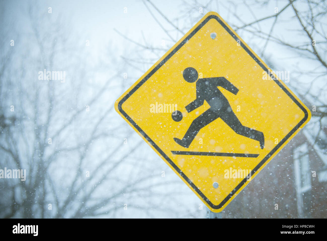A chidren playing road sign with heavy snow during a storm or blizzard ...