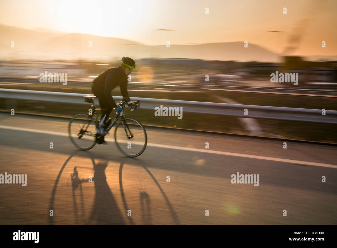Fast bicycle rider on highway and on sunset with motion blur Stock ...