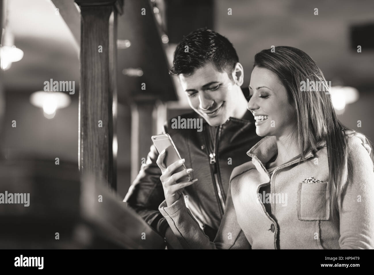 Fashionable couple spending time together, she is holding a mobile ...