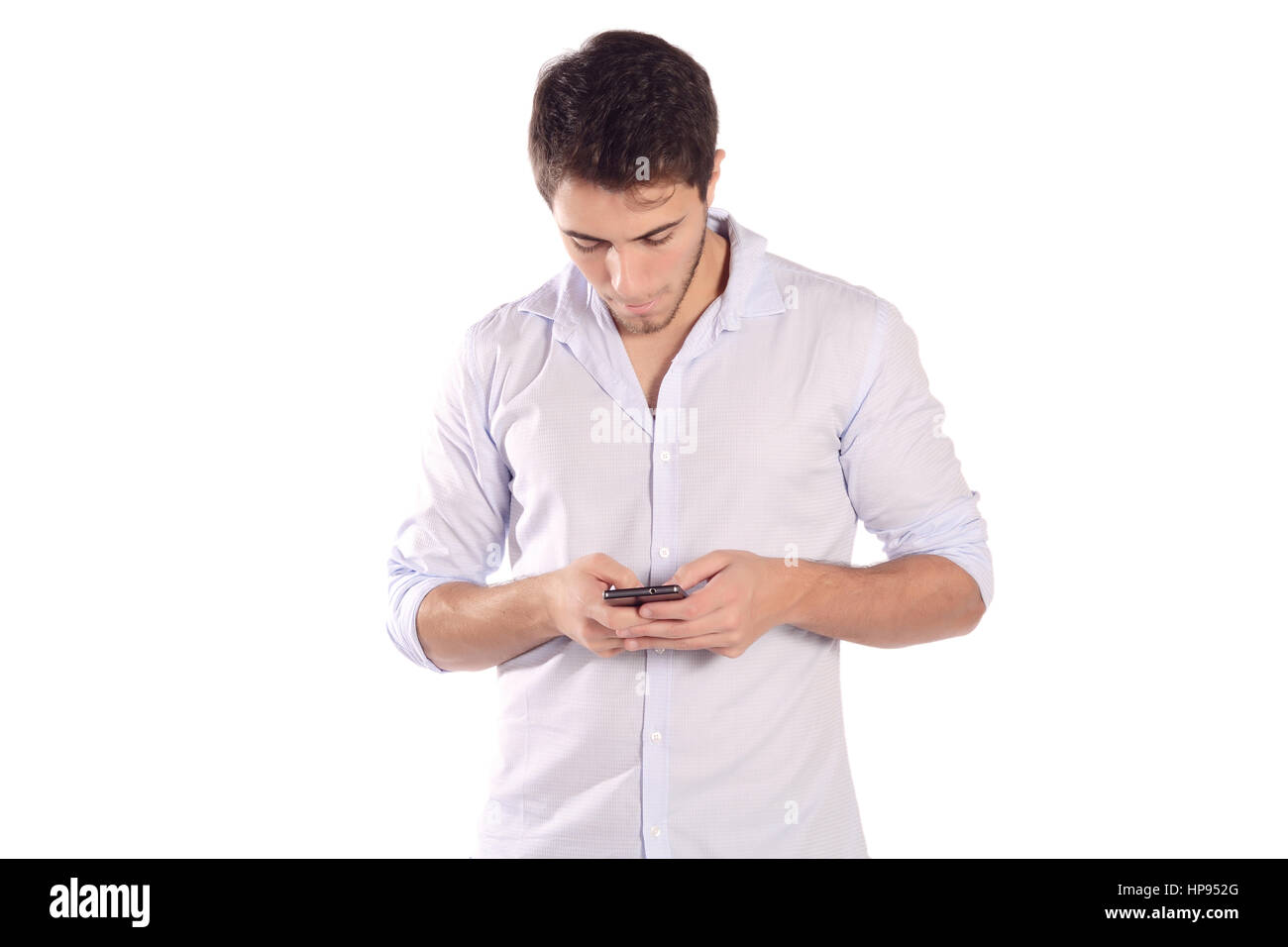 Portrait of a young man typing on his smartphone. Isolated white ...