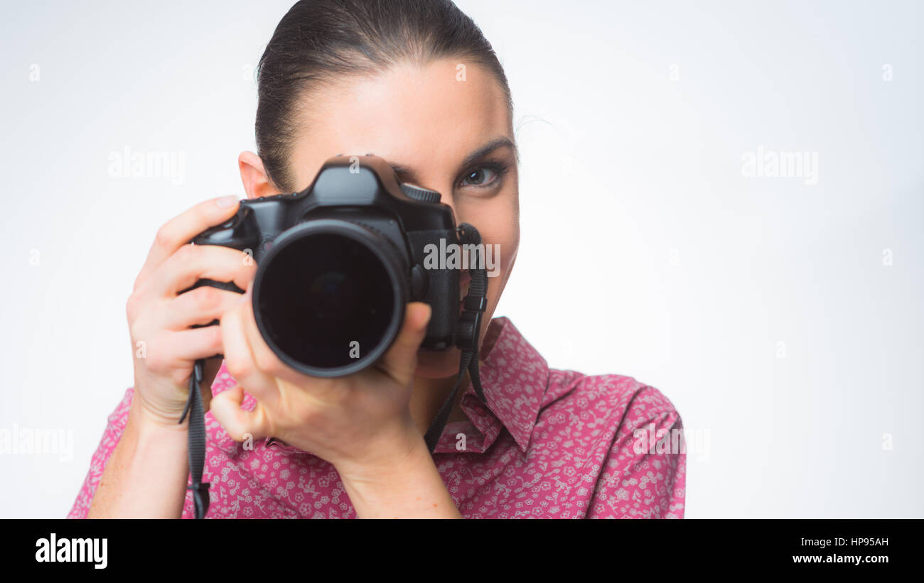 Female photographer shooting with a dslr camera on white background ...