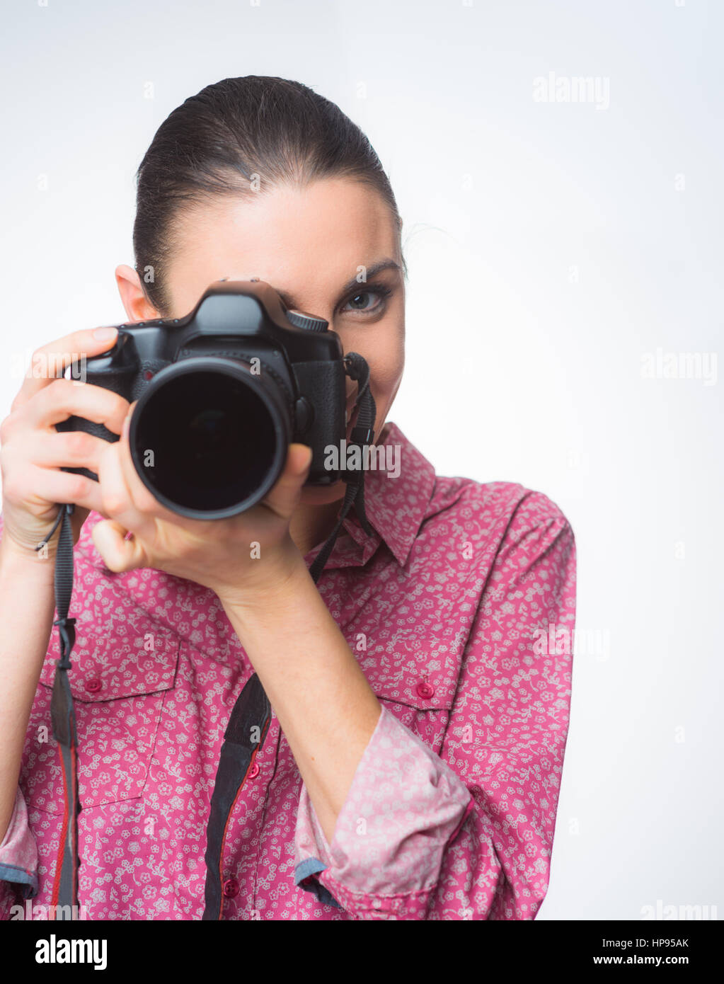 Female photographer shooting with a dslr camera on white background ...