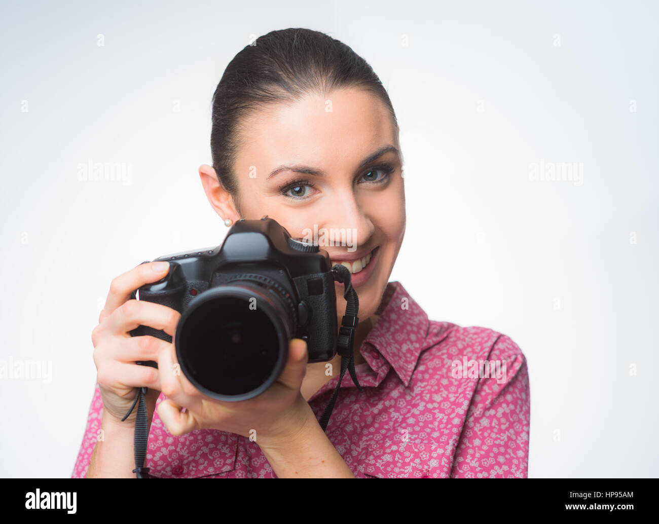 Female photographer shooting with a dslr camera on white background ...