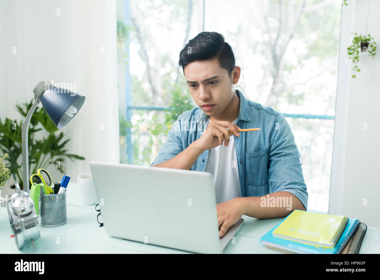 Student doing homework and preparing exam at home Stock Photo - Alamy