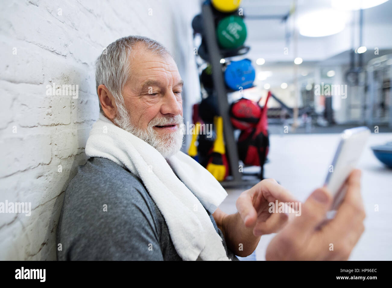 Fit senior man in gym resting, holding smart phone Stock Photo - Alamy