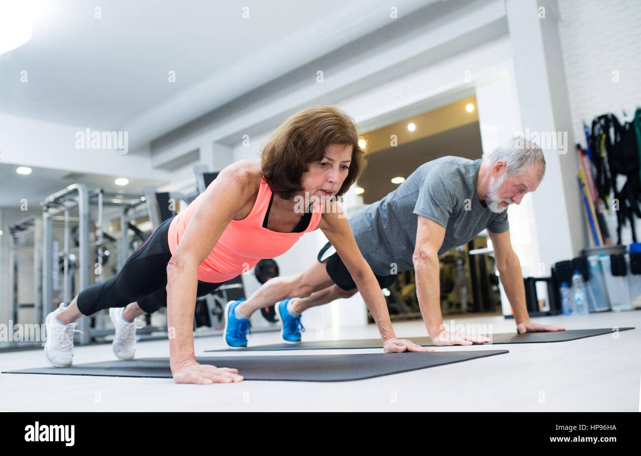 Senior couple in gym working out, doing push ups Stock Photo - Alamy