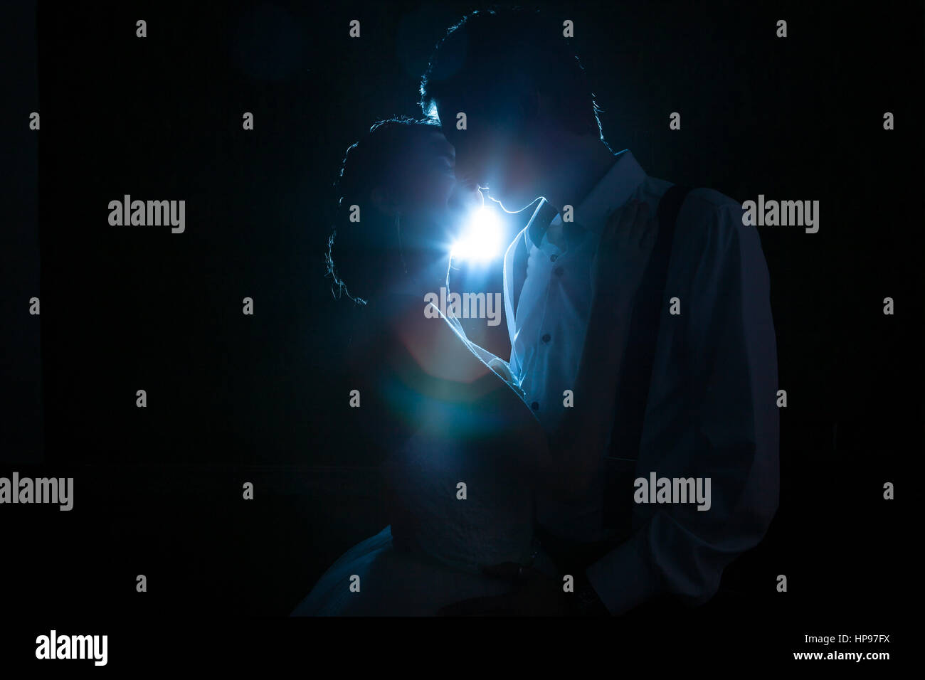 Couple backlit with a blue light. Studio photo Stock Photo - Alamy