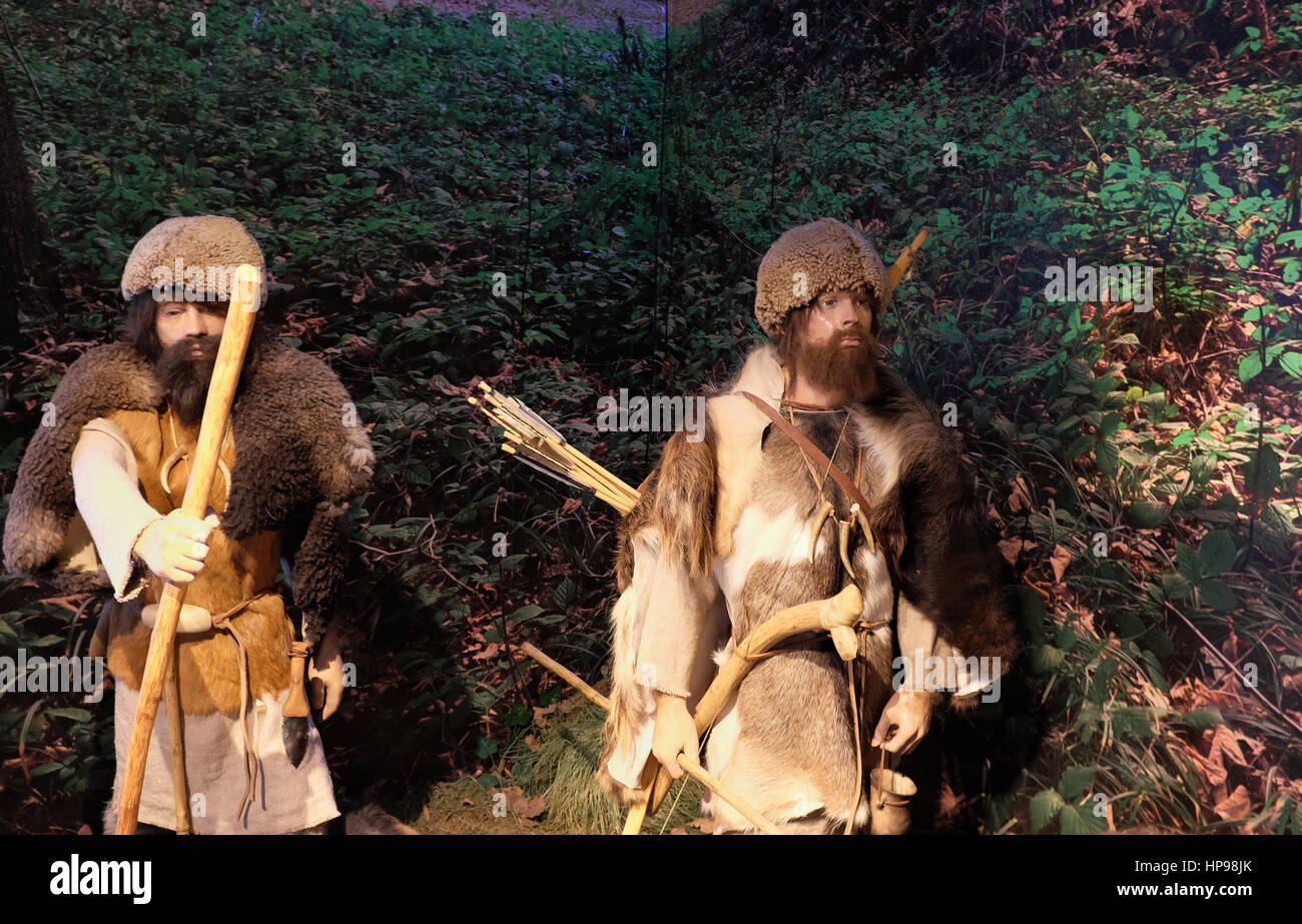 Hunters with bows and arrows wear in animal skins and caps, Trzcinica ...