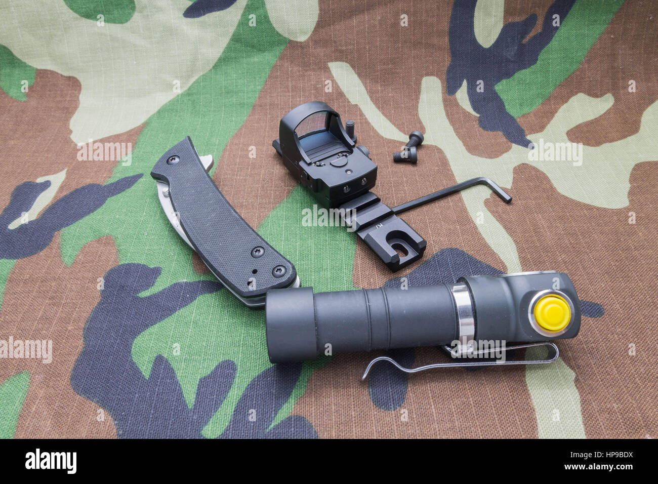 Military set on camouflage background from a flashlight, and the sight ...