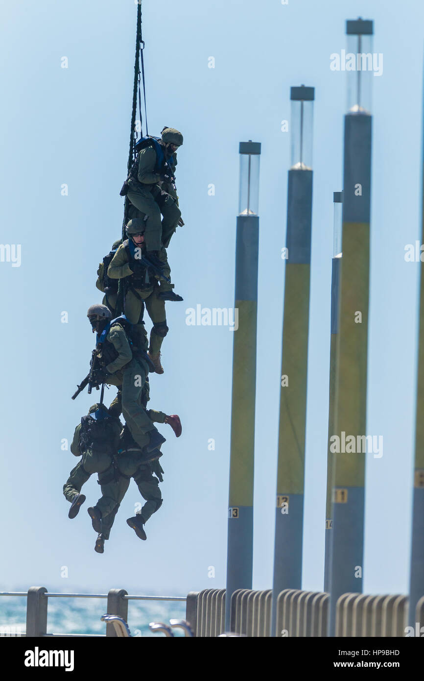 Soldiers attached to rope flying airlift below helicopter military ...