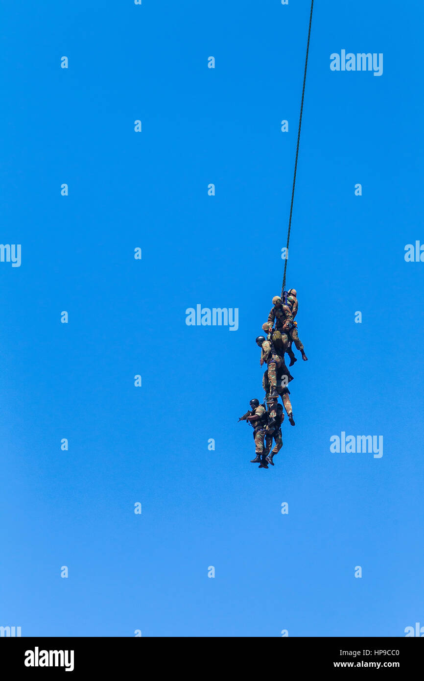 Soldiers attached to rope flying airlift below helicopter military ...