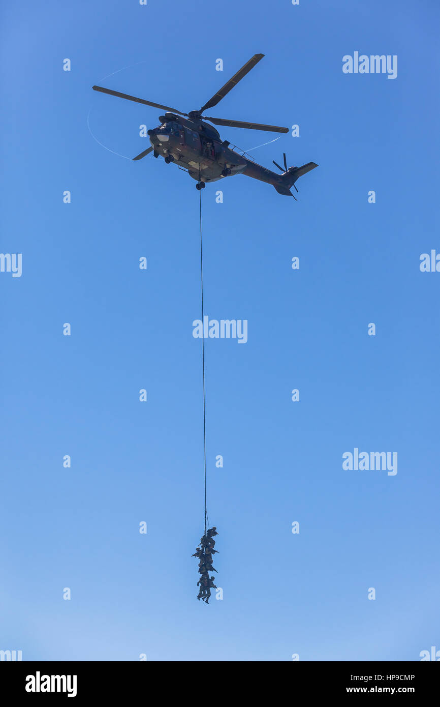 Soldiers attached to rope flying airlift below helicopter military ...