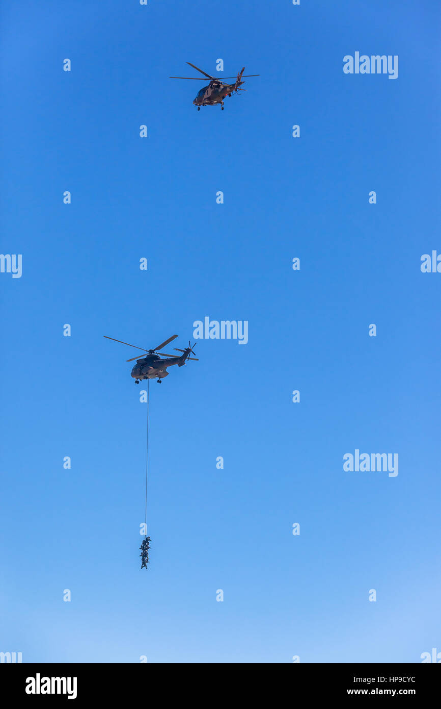 Soldiers attached to rope flying airlift below helicopter military ...