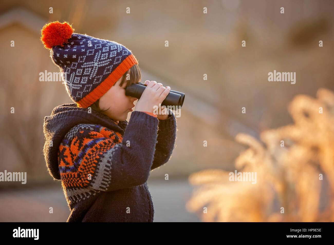 Cute little child, boy, exploring nature with binoculars, looking at ...