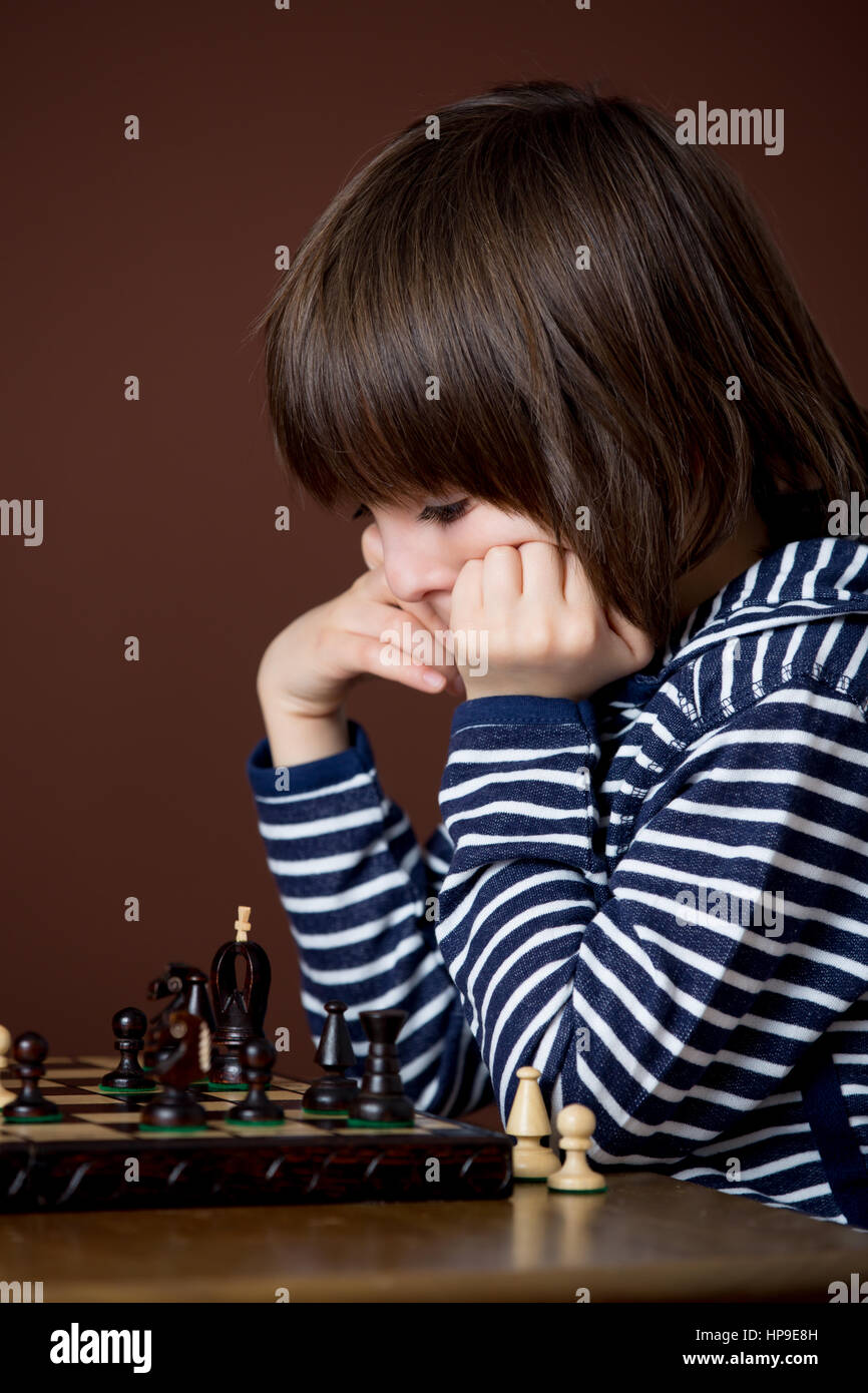 Little boy, playing chess. Smart kid, isolated, playing chess. Children ...