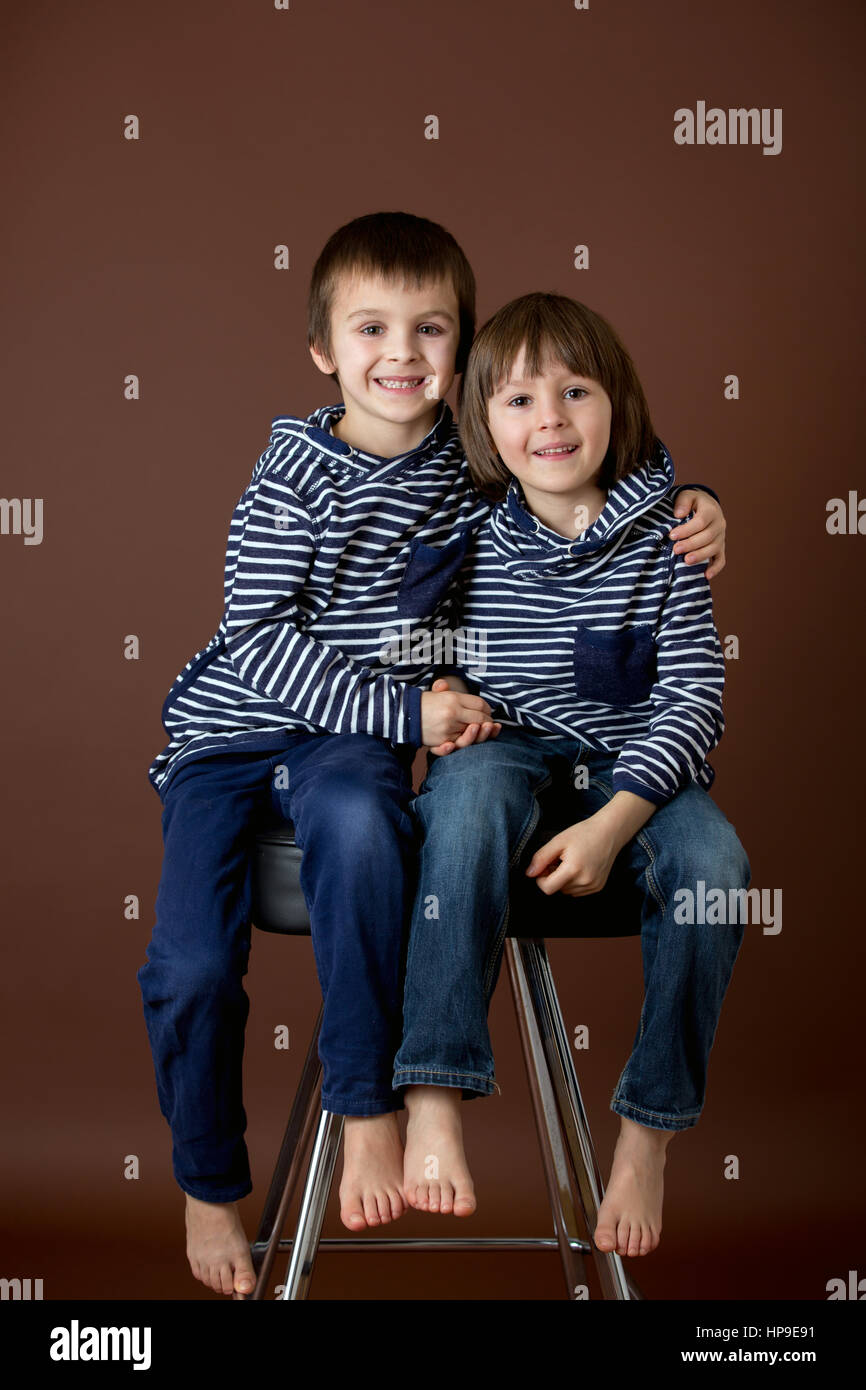 Double portrait of two boys, brothers, isolated on brown Stock Photo ...