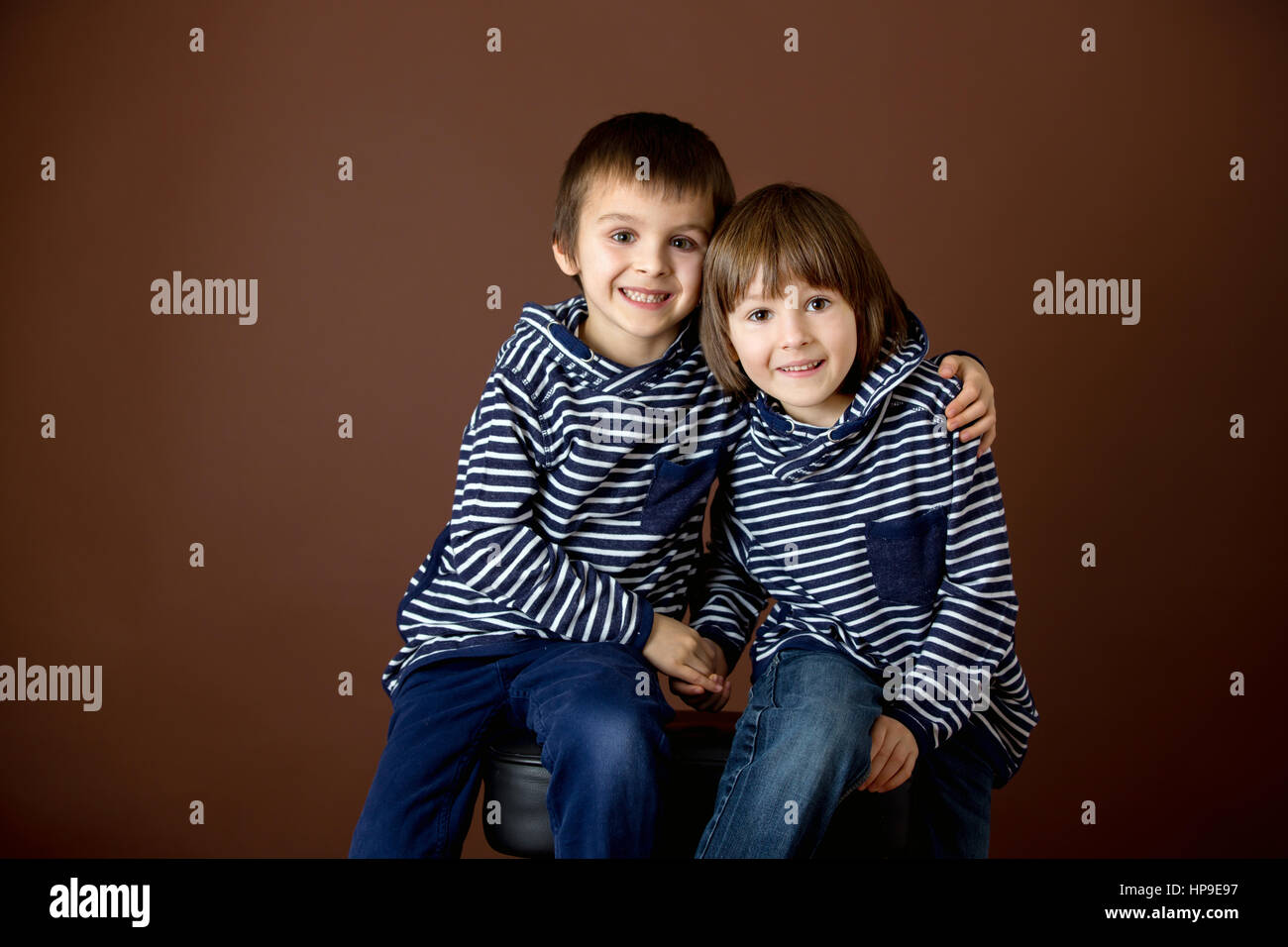 Double portrait of two boys, brothers, isolated on brown Stock Photo ...