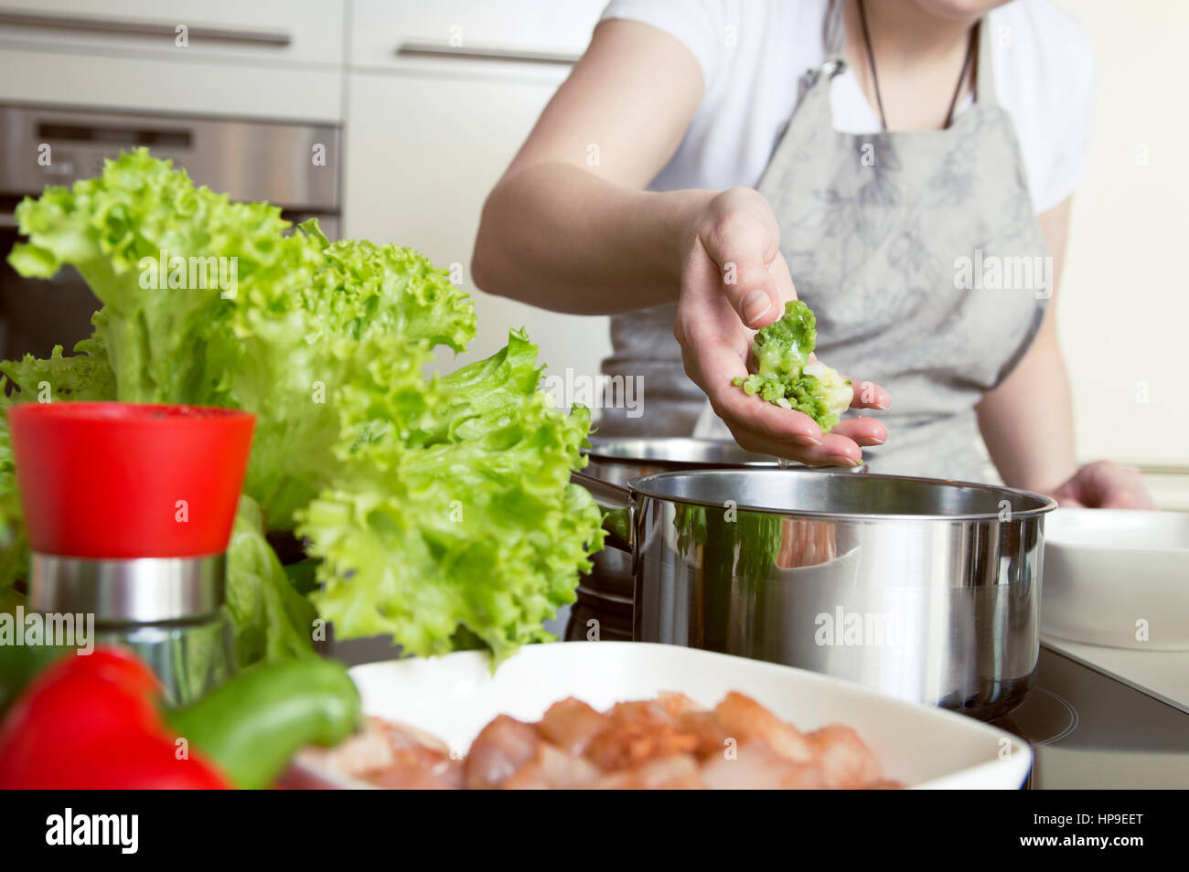 Woman puts vegetables into the pot. Conception of healthy food ...
