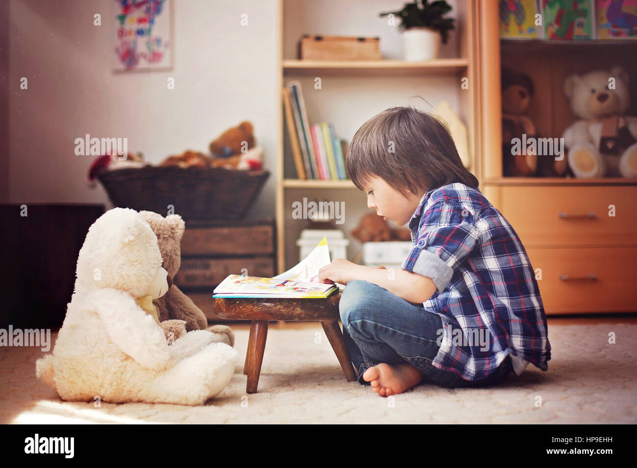 Cute little child, preschool boy, reading a book to his teddy bears at ...