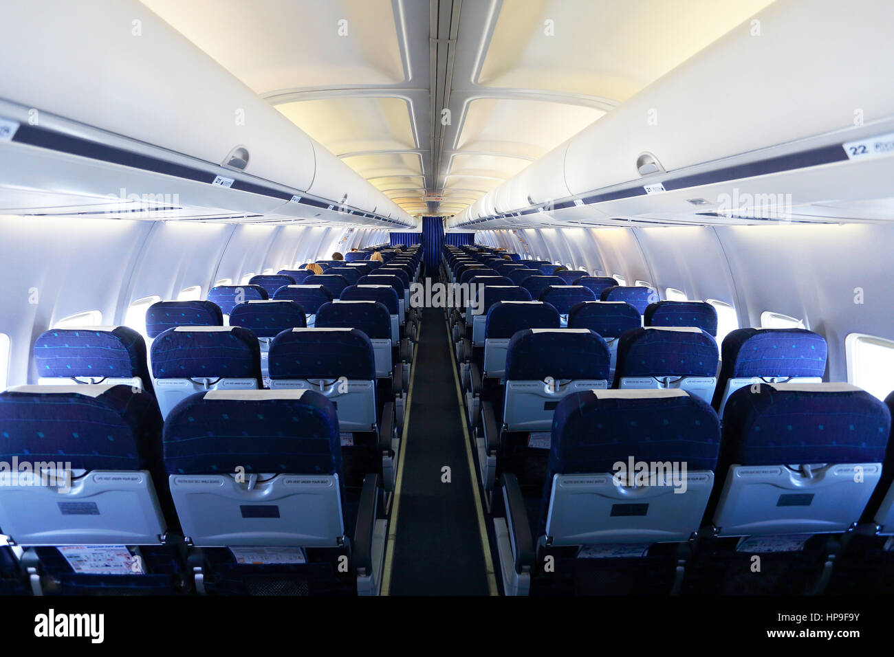 Aircraft interior with blue seats and white panel Stock Photo - Alamy