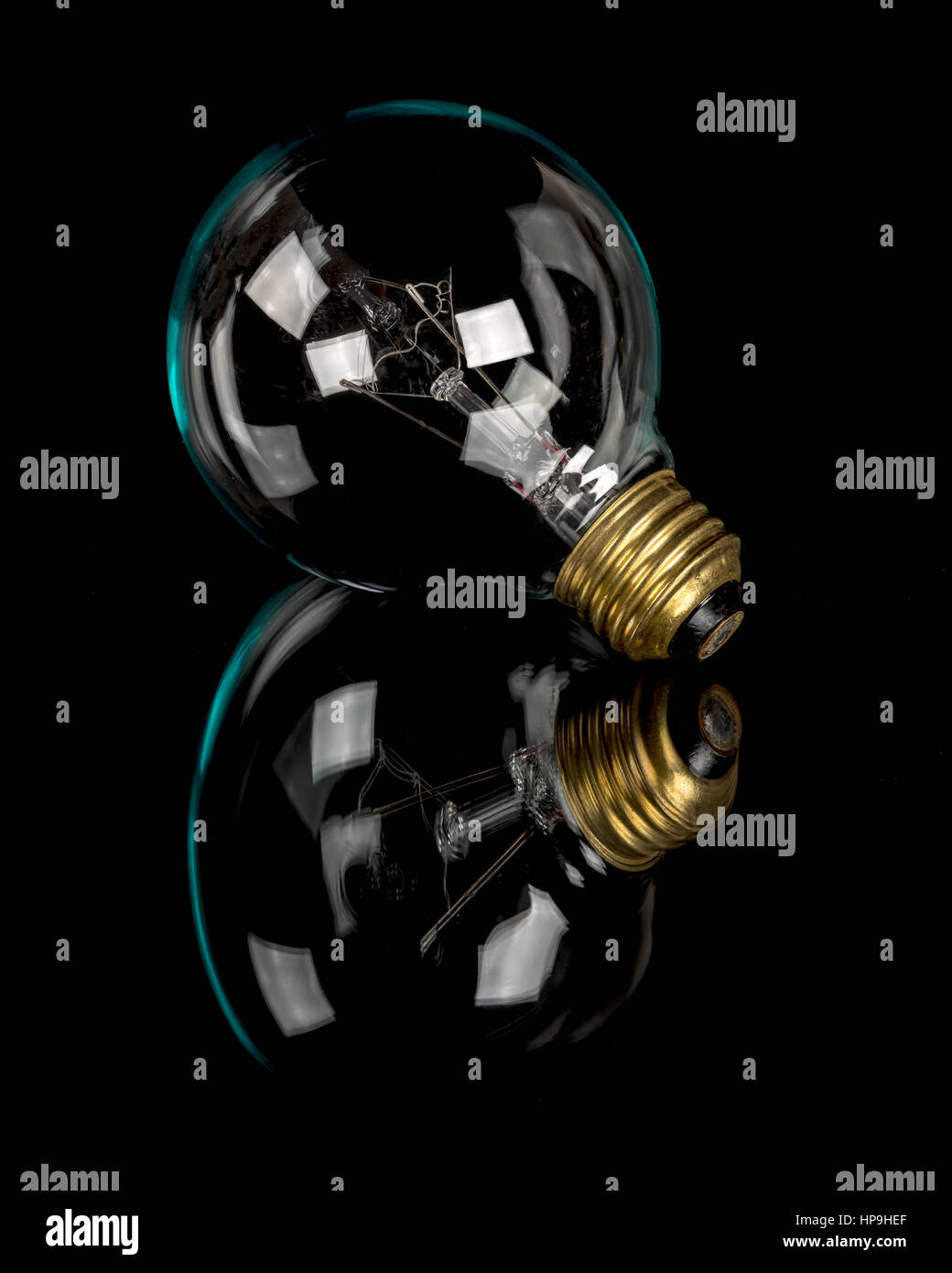 Single light bulb on a reflective surface Stock Photo - Alamy