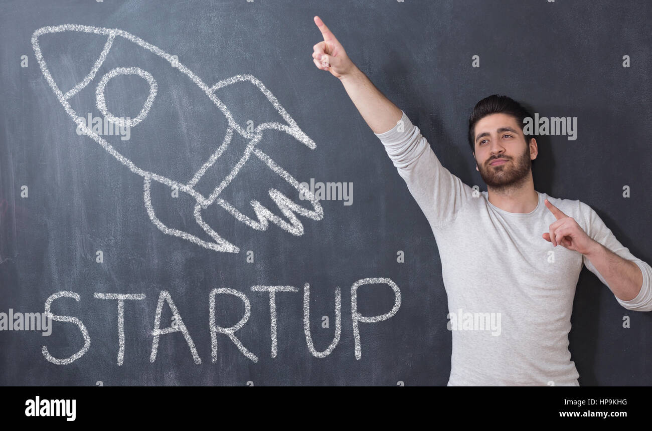 Startup business concept. Portrait of man on chalkboard background ...