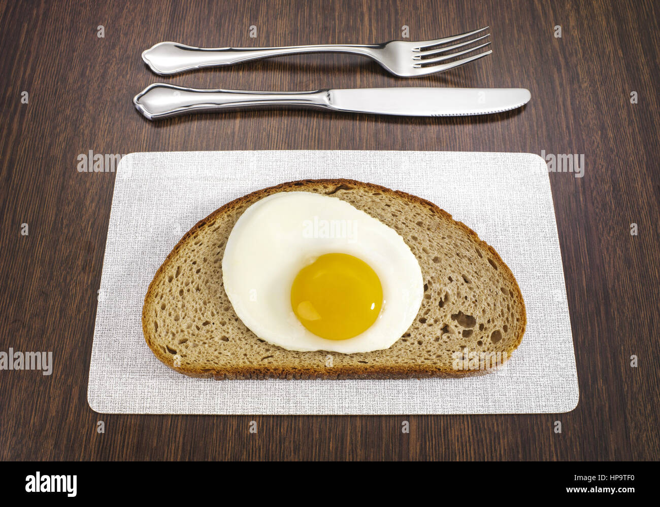 Scheibe Brot mit Spiegelei, Besteck Stock Photo - Alamy