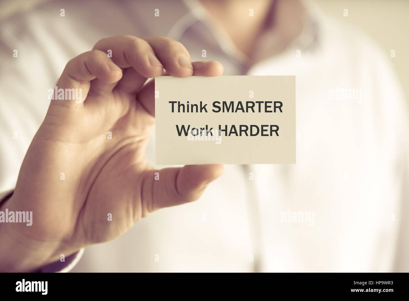 Closeup on businessman holding a card with text THINK SMARTER WORK ...