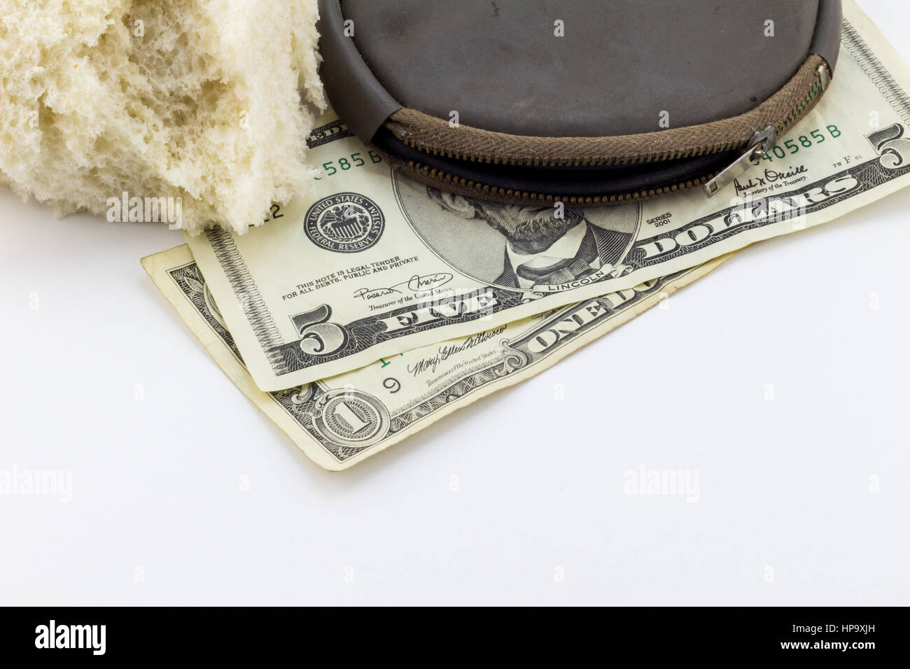 Old wallet / purse with dollar notes and a crust of bread on white ...