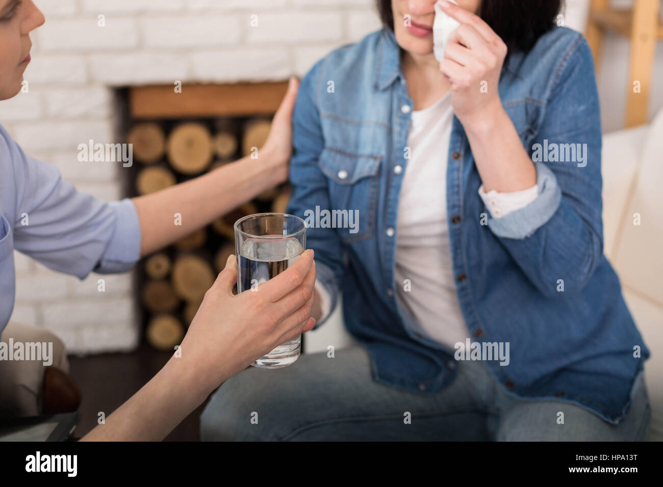 Nervous breakdown. Close up of a glass filled with water being given to ...