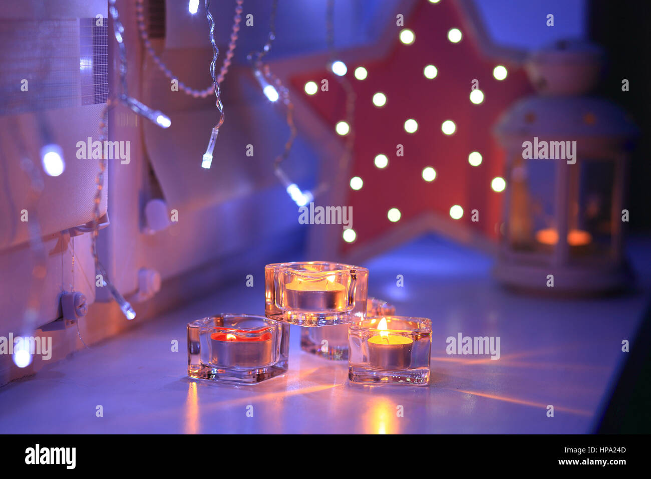 Bright candles and decorative lights at night. Candles on soft focus ...