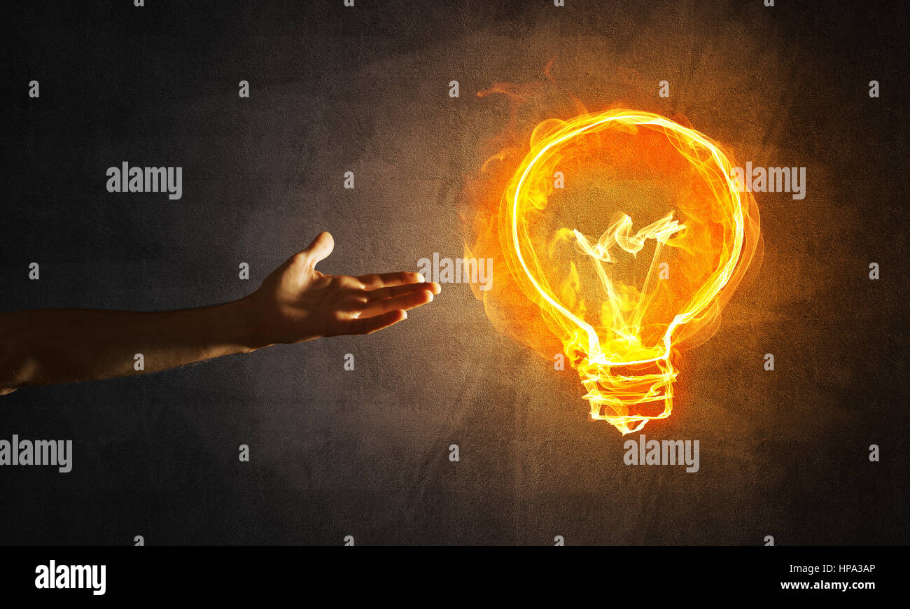 Close of man hand showing at glowing fire light bulb icon Stock Photo ...