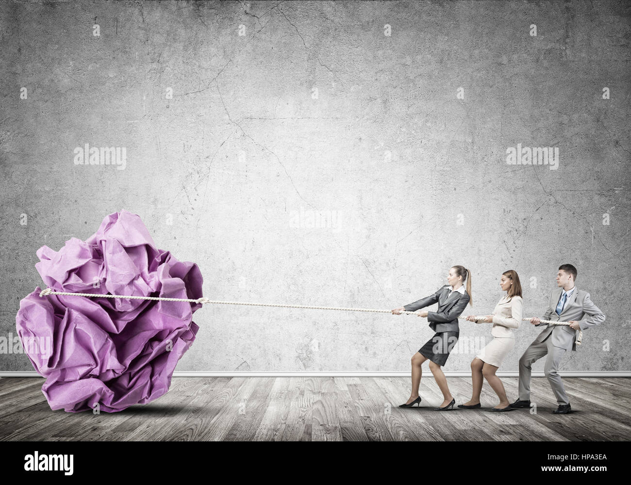 Office employees pulling together big crumpled paper ball Stock Photo ...