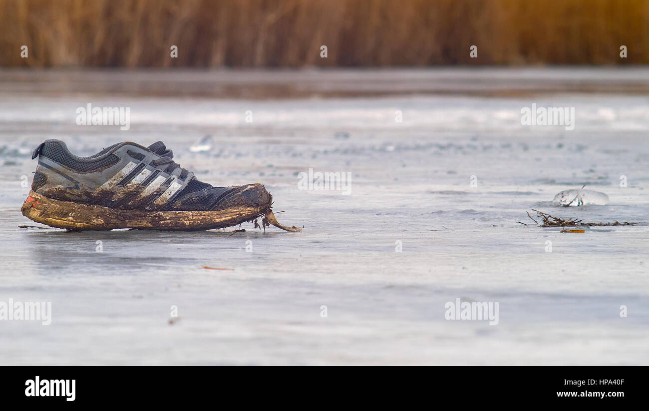 The dirty Sneaker and dirt froze on the ice Stock Photo - Alamy