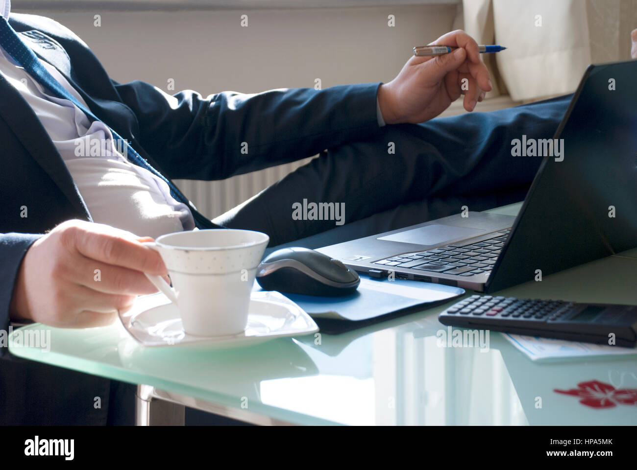 Business man listening while working from home on a laptop computer ...