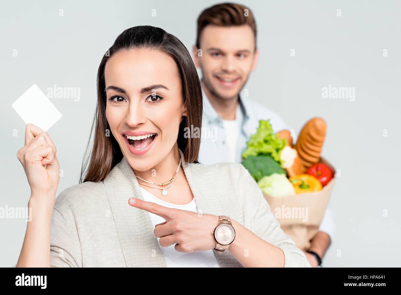woman pointing to credit card in hand with man behind Stock Photo - Alamy