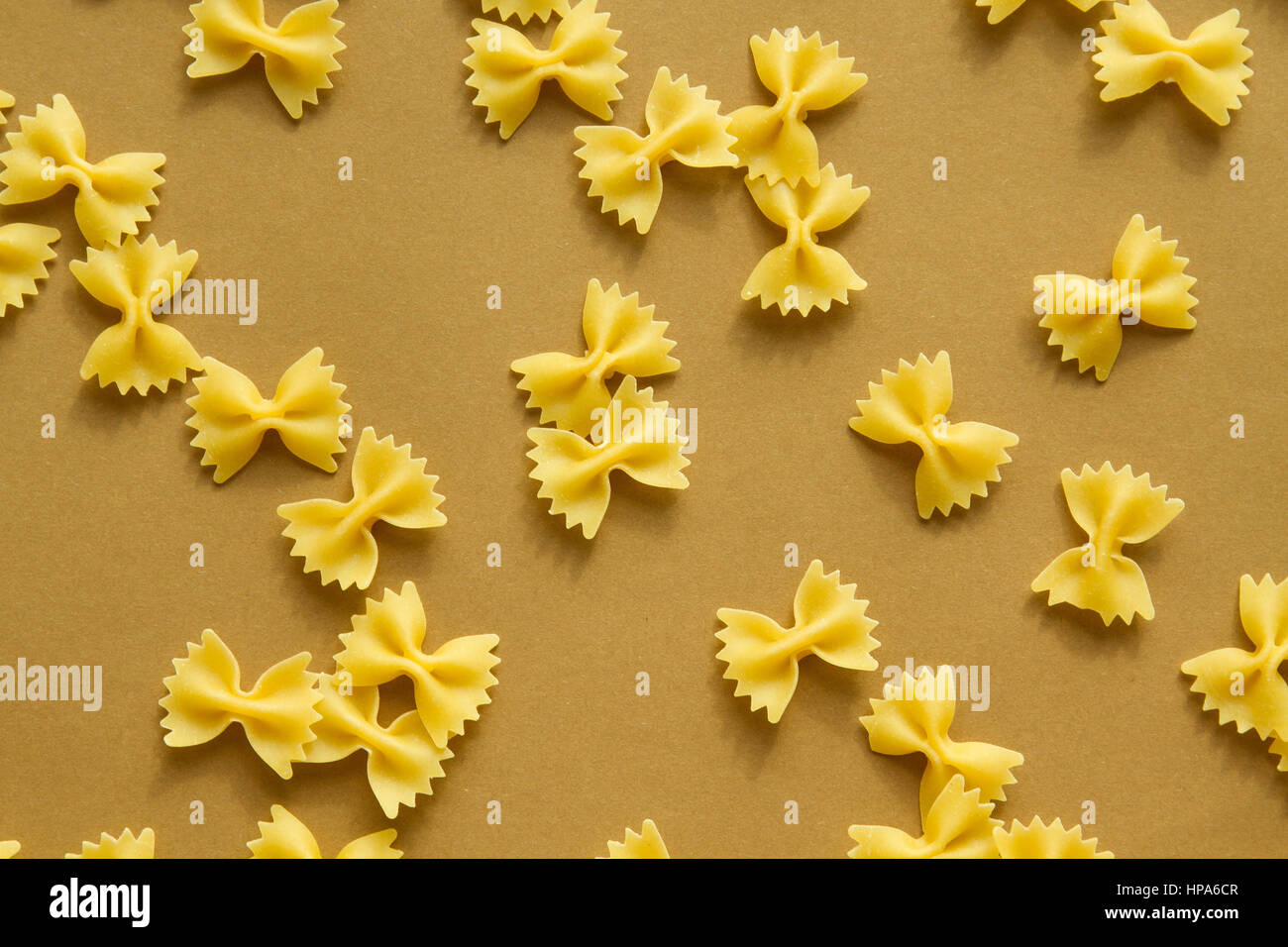 Pasta bow shape on brown background Stock Photo - Alamy