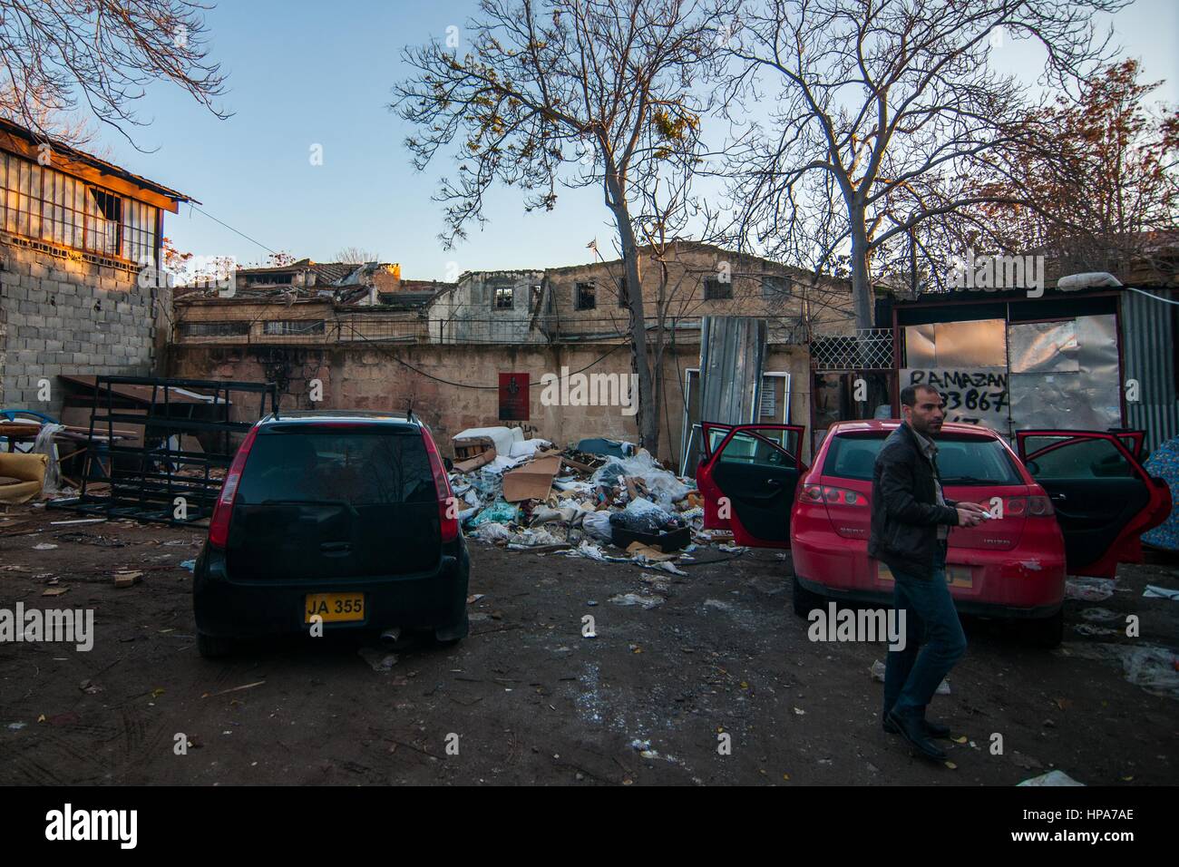 A man work out his house next to the wall that divide the city of ...